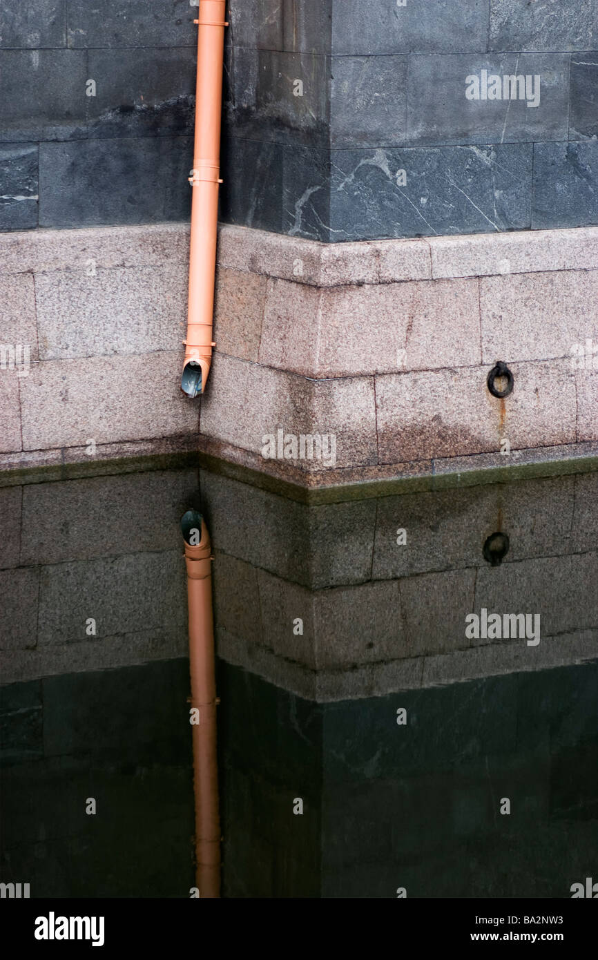 Drain pipe on granite wall over water Stock Photo - Alamy