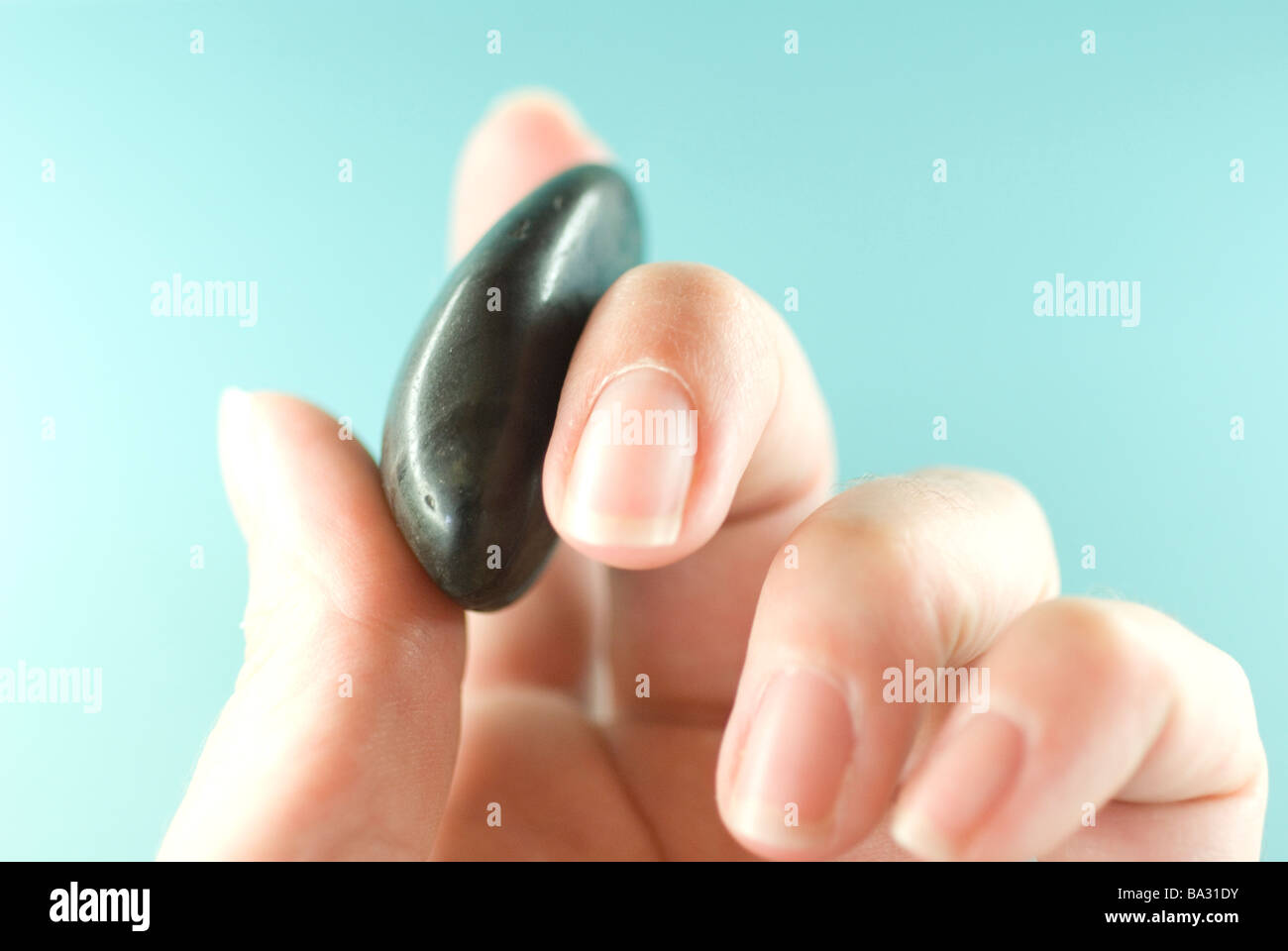 hand holding a black stone Stock Photo - Alamy
