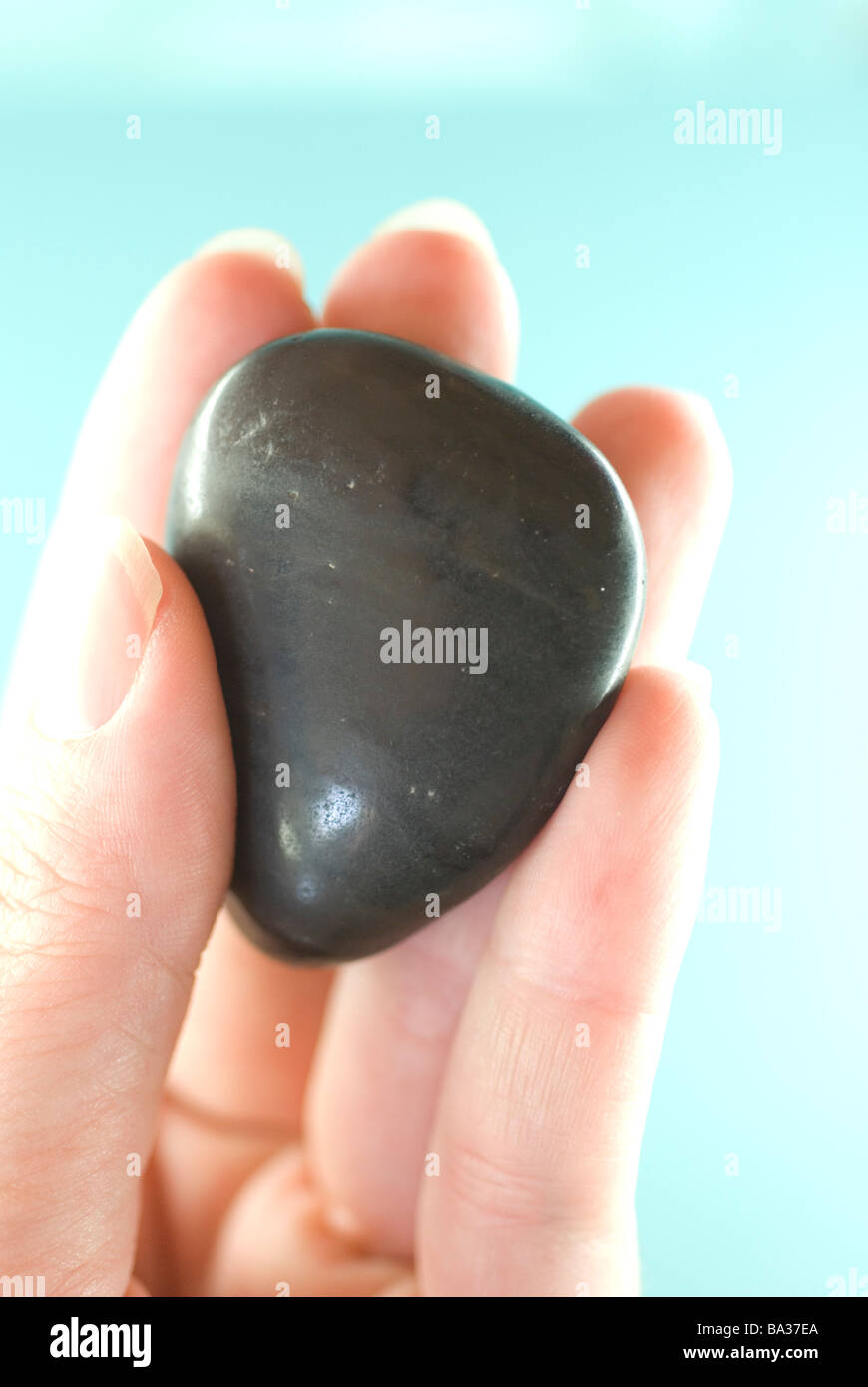 hand holding a black stone Stock Photo - Alamy