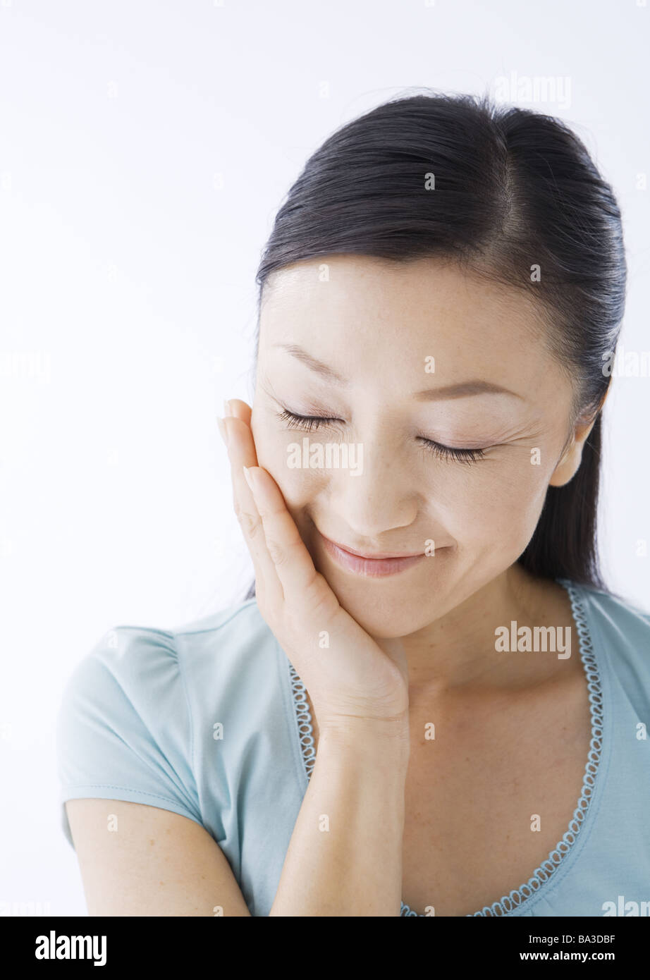 A woman touching her cheek Stock Photo - Alamy