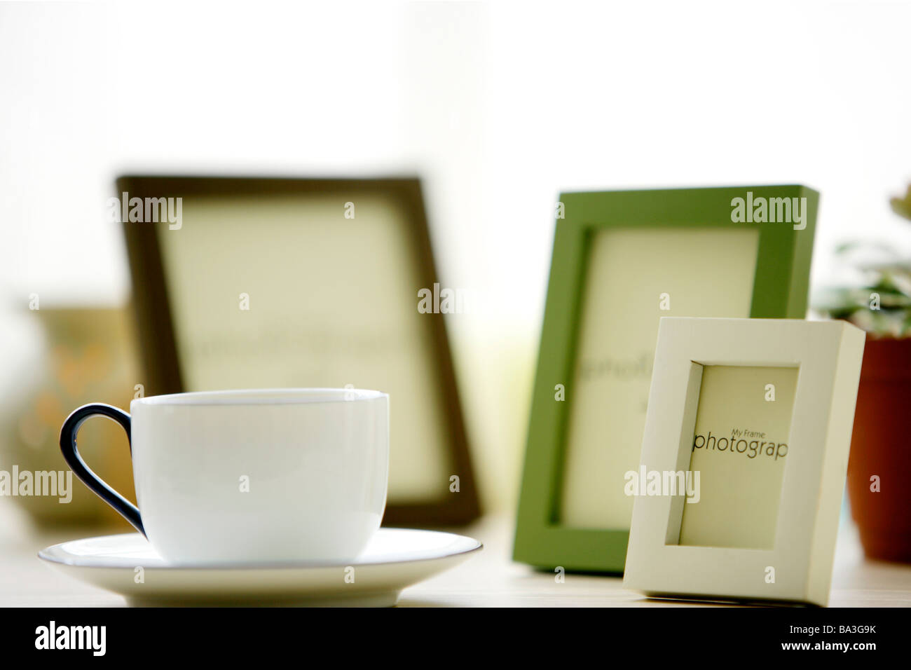 Three colorful picture frames and cup on table close up Stock Photo - Alamy