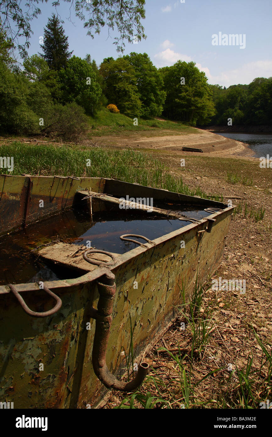 A rusty old metal boat with peeling paint and full of water abandoned ...