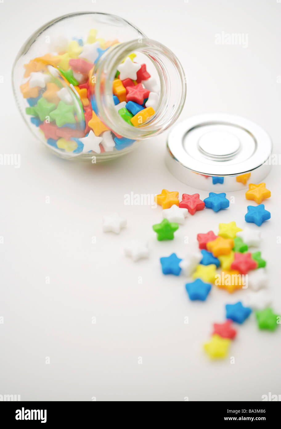 Candy stars in and beside jar Stock Photo - Alamy