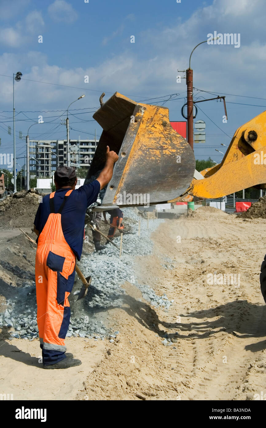 Worker and road loader Stock Photo - Alamy