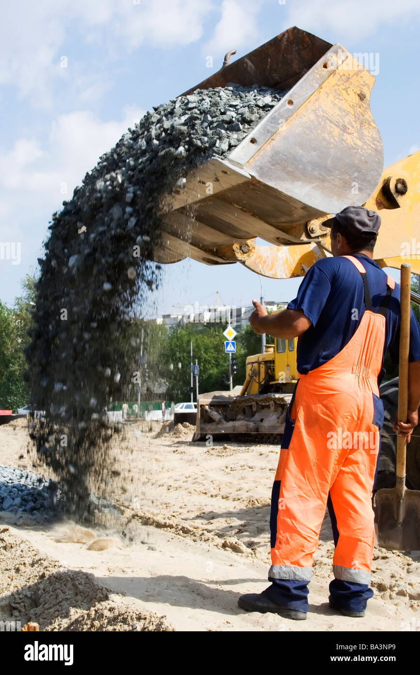 Worker and road loader Stock Photo - Alamy
