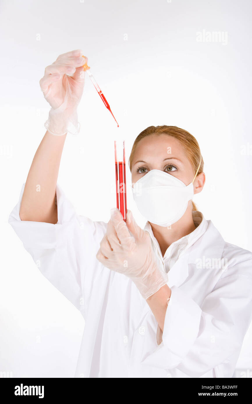 Female scientist dropping liquids into test tube with pipette Stock ...
