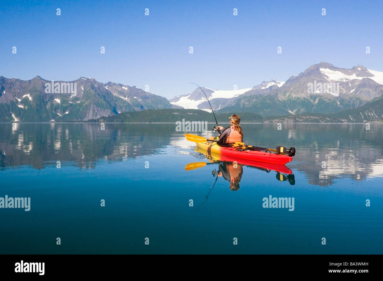 Female fisherwoman in kayak fishing for salmon in Abra Cove Aialik Bay ...