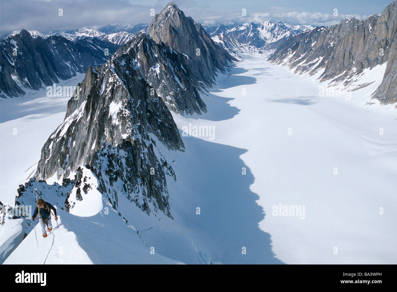 Mountaineer climbing on narrow ridge in Kichatna Mtns Denali National ...