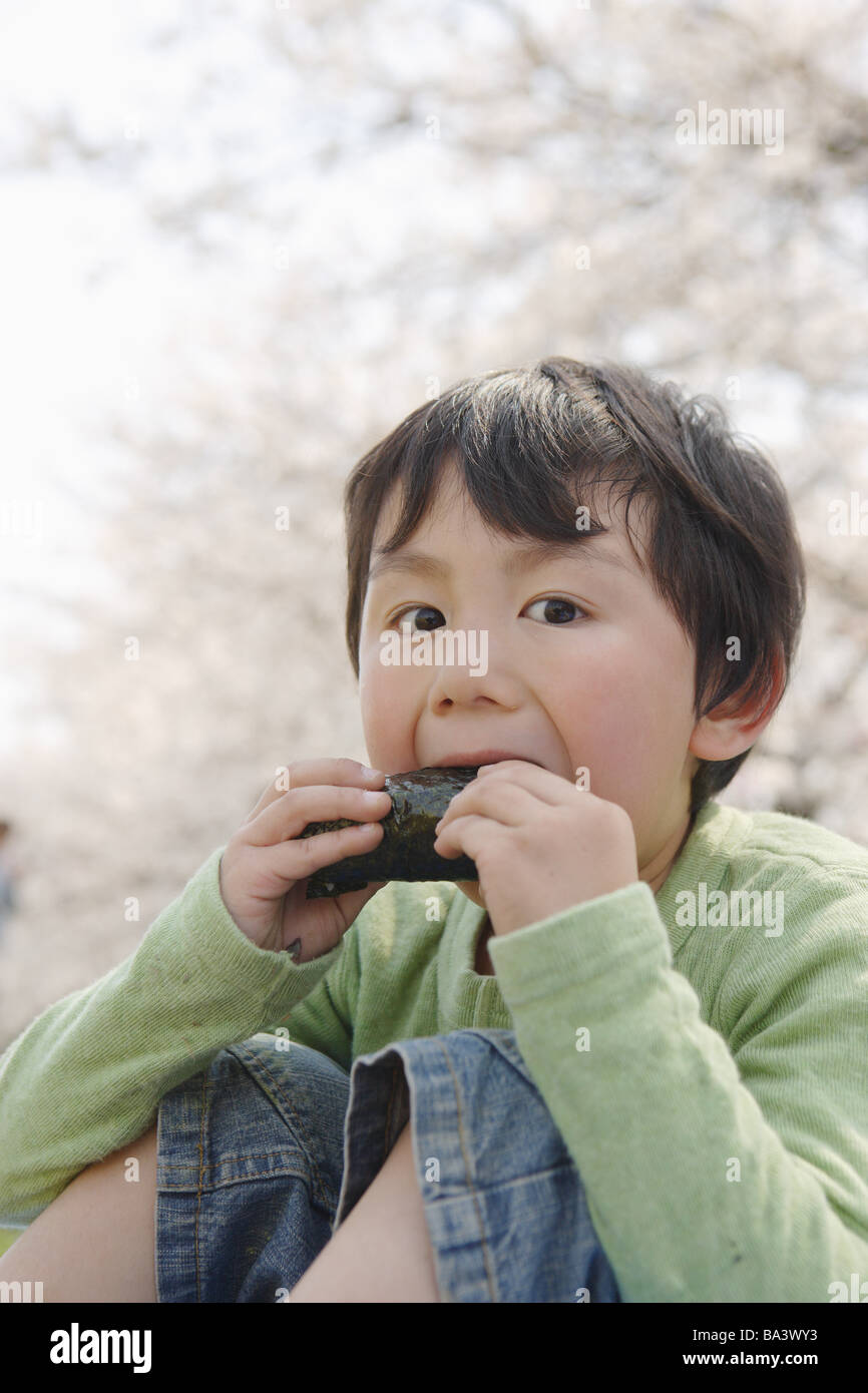 Japanese boy eating sushi and looking at camera Stock Photo - Alamy