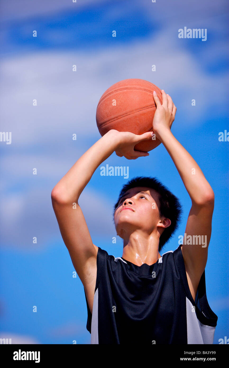 Teenage boy preparing to throw basketball Stock Photo - Alamy