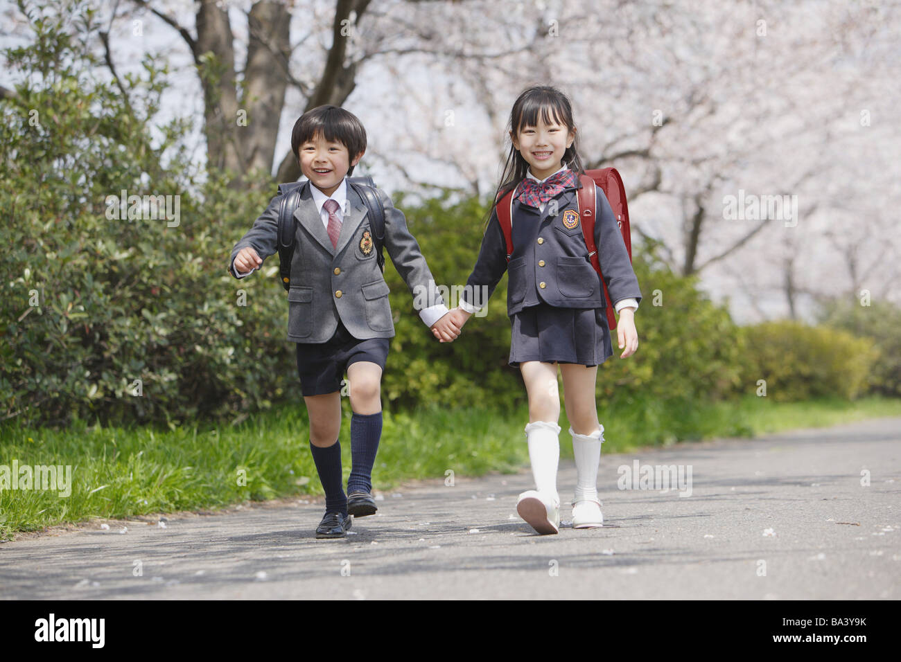 Schoolmate going to school and looking at camera Stock Photo - Alamy