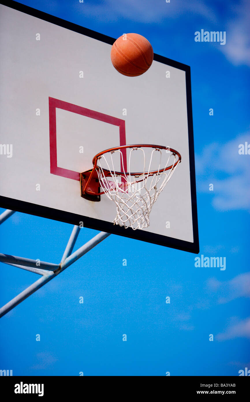 Basketball over basketball hoop Stock Photo - Alamy