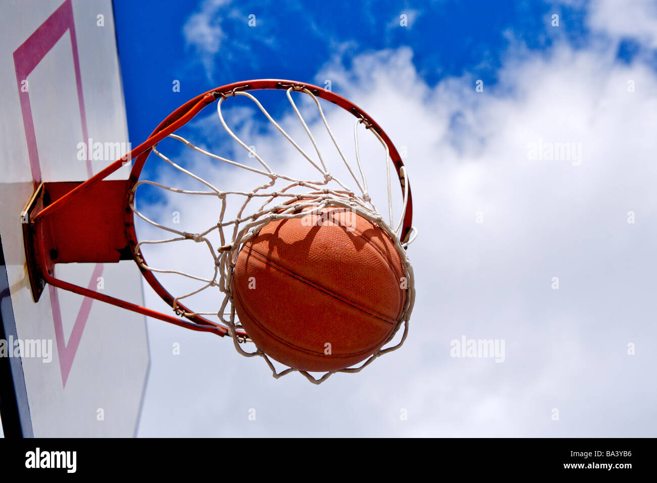 Basketball going through hoop Stock Photo - Alamy