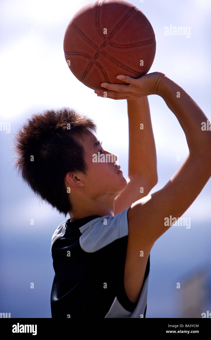 Teenage boy preparing to throw basketball Stock Photo - Alamy