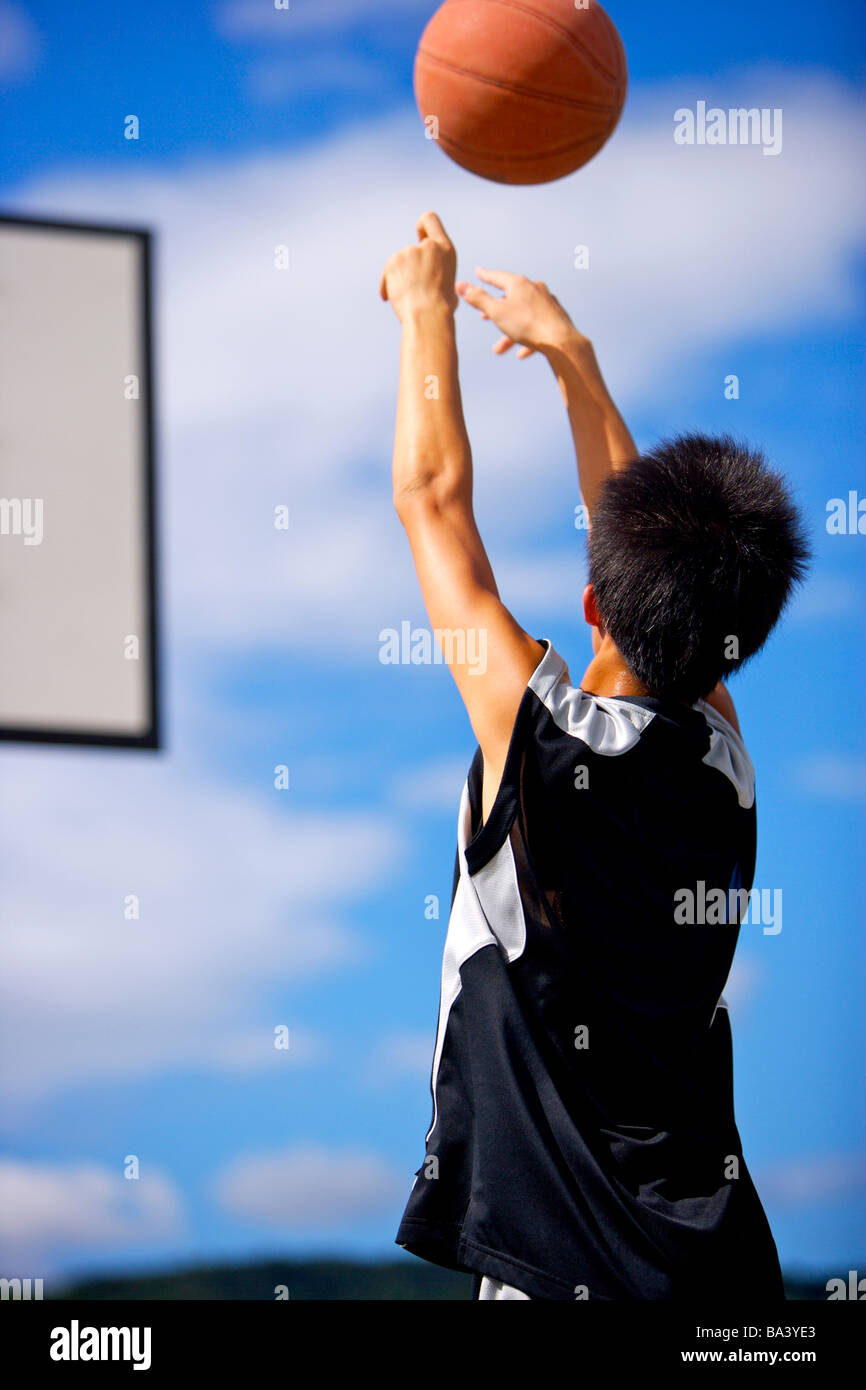 Teenage boy throwing basketball Stock Photo - Alamy