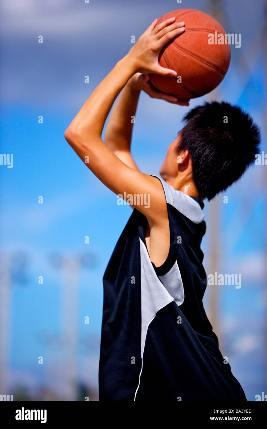 Teenage boy preparing to throw basketball Stock Photo - Alamy