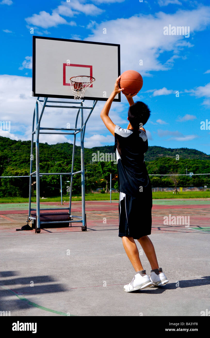 Teenage boy preparing to throw basketball Stock Photo - Alamy