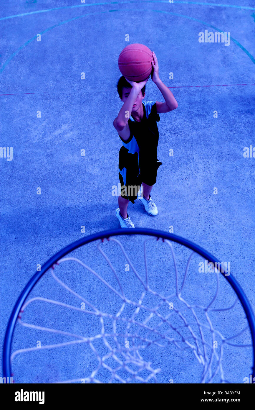 Teenage boy preparing to throw basketball high angle view Stock Photo ...