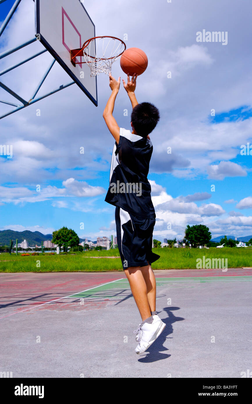 Teenage boy throwing basketball Stock Photo - Alamy