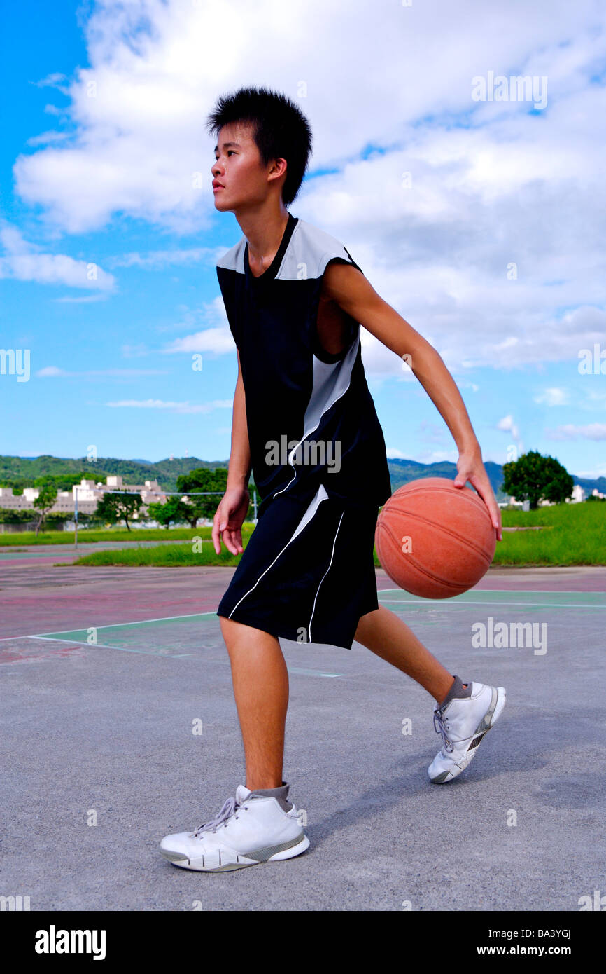 Teenage boy dribbling basketball Stock Photo - Alamy