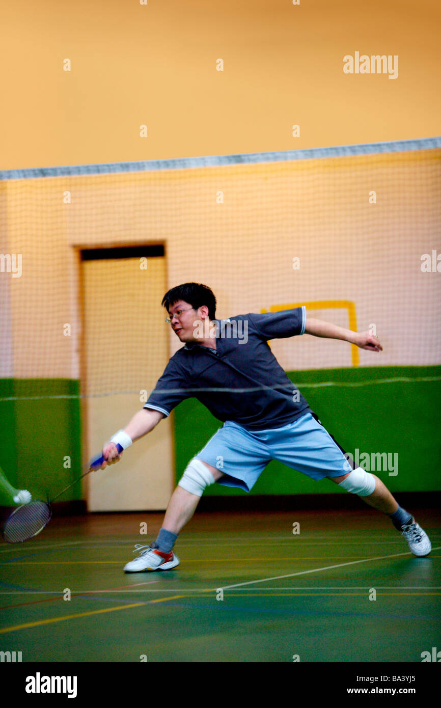 Man hitting shuttlecock with badminton racket Stock Photo - Alamy