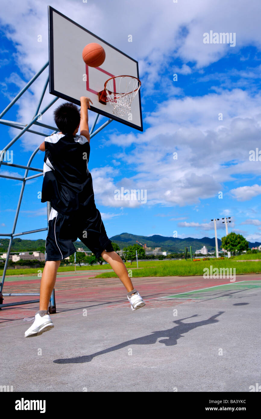 Teenage boy shooting a basketball Stock Photo - Alamy
