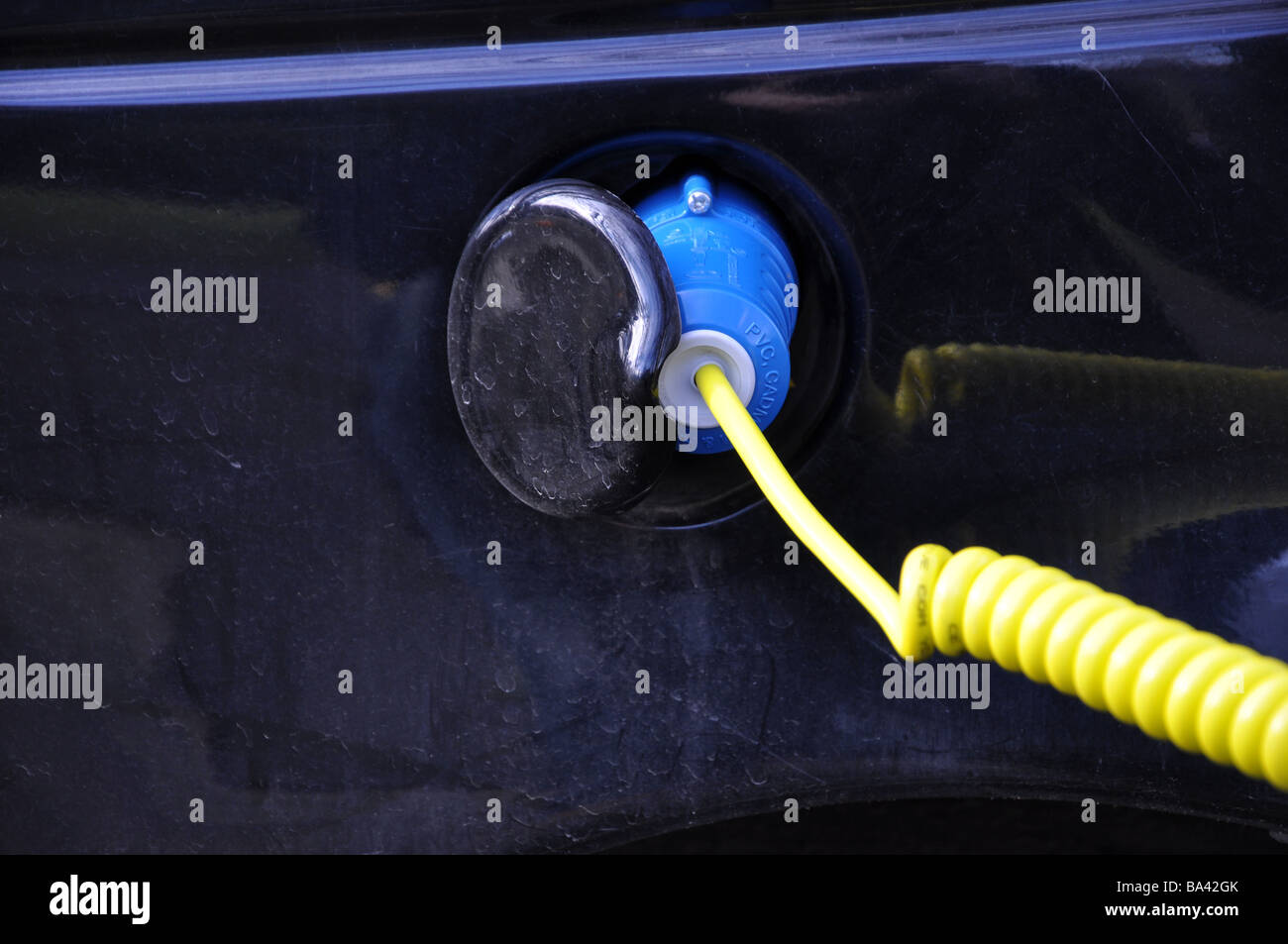 Electric car charged with cable plugged in Stock Photo - Alamy