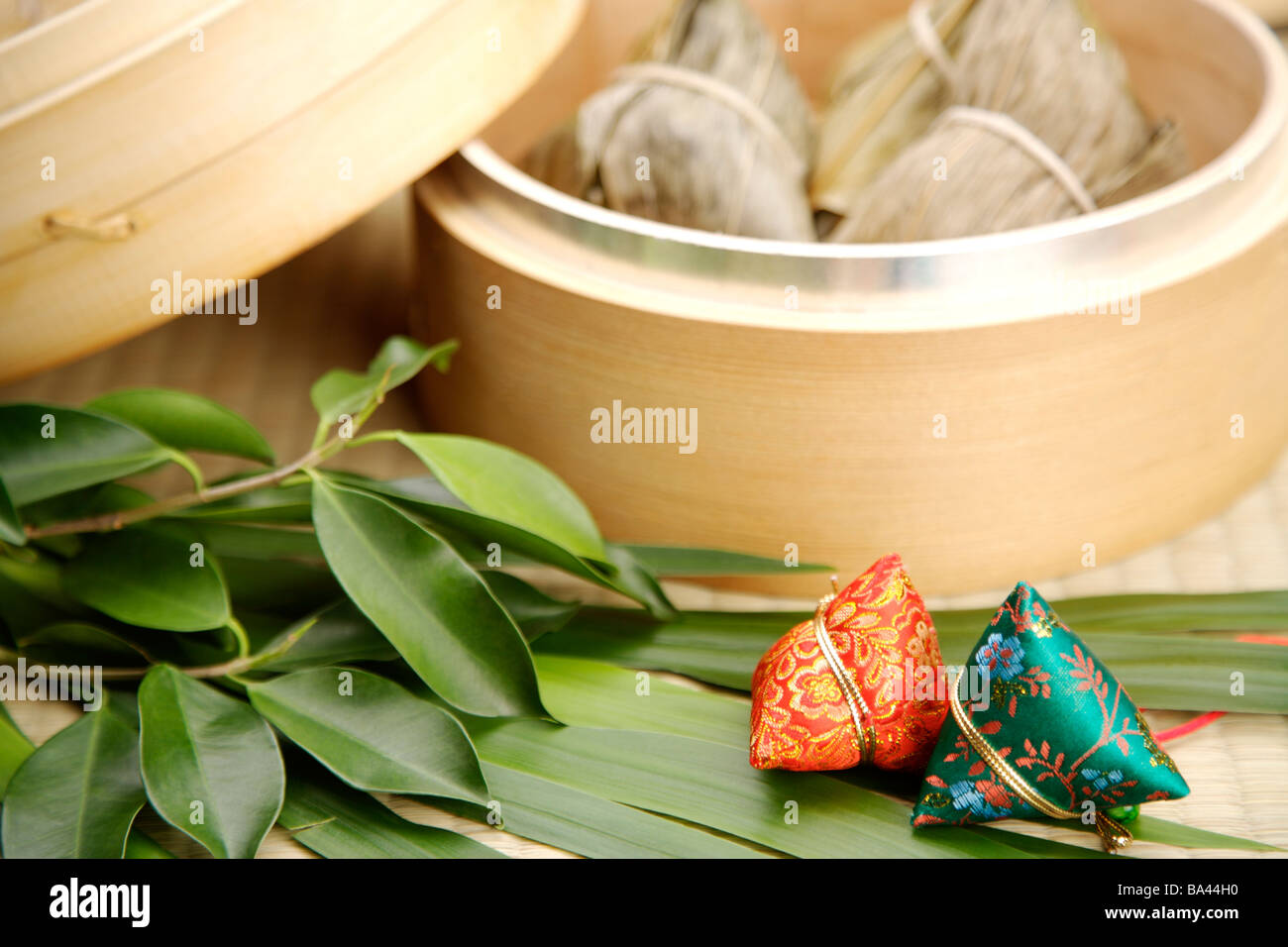 Two chinese rice dumplings wrapped in satin and steamer with chinese ...