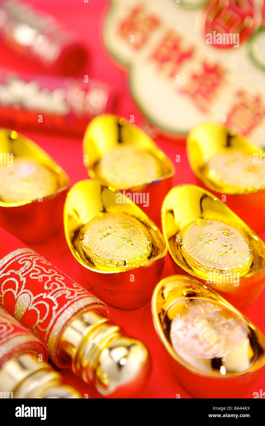 Gold ingots and rolled chinese couplets Stock Photo - Alamy