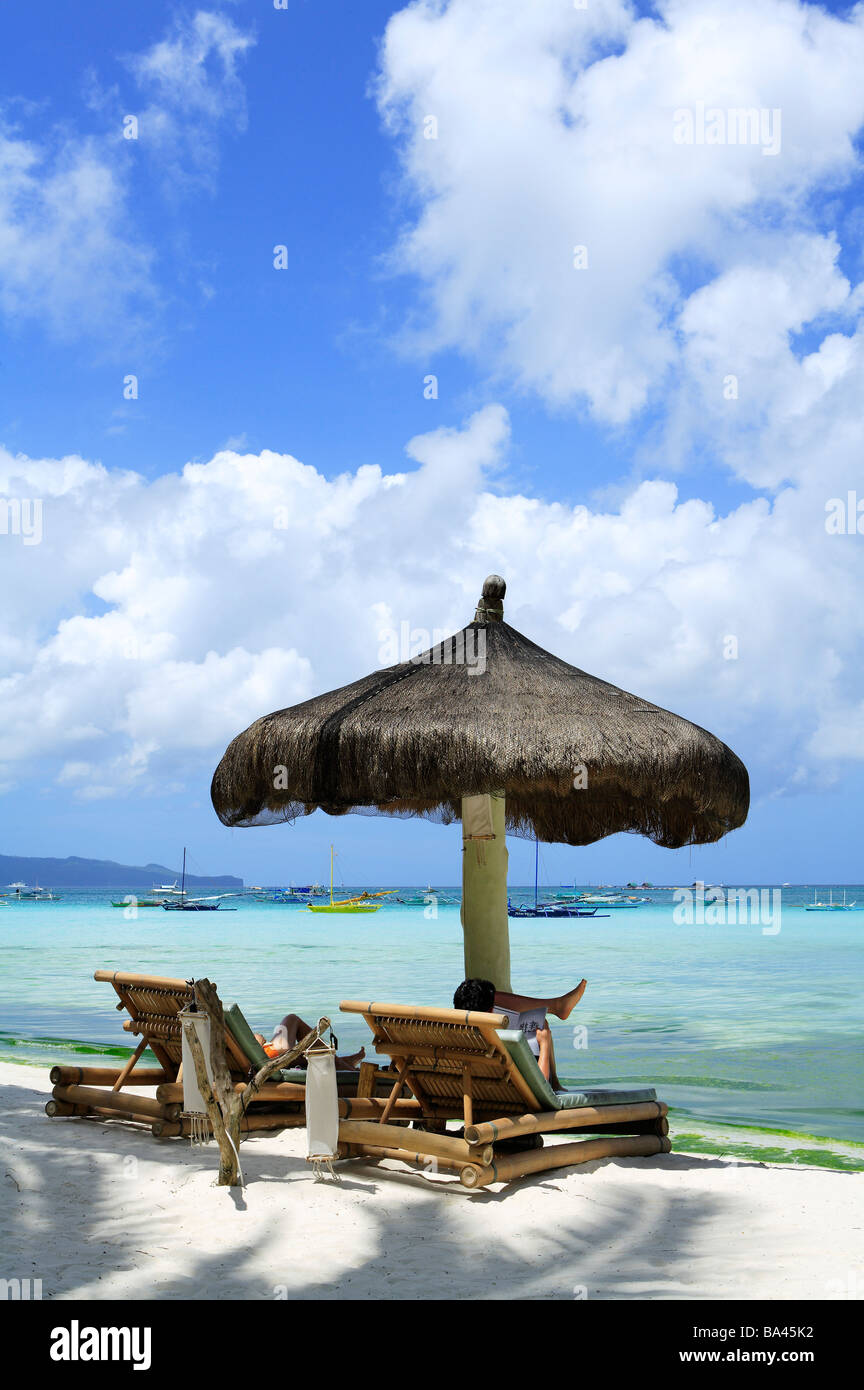 People sitting on the beach chair relaxing Stock Photo - Alamy
