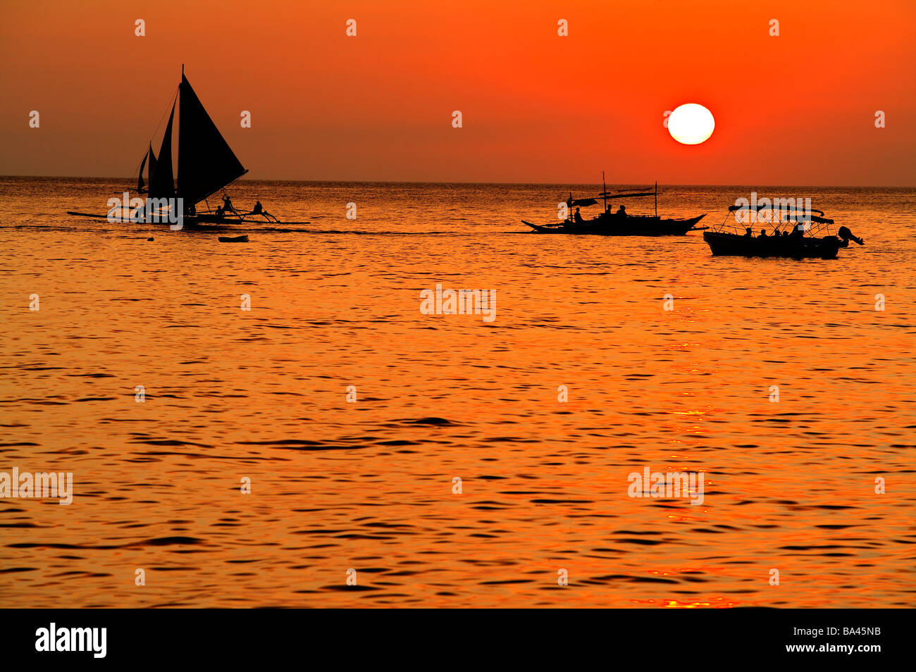 Boats traveling at the sunset Stock Photo - Alamy