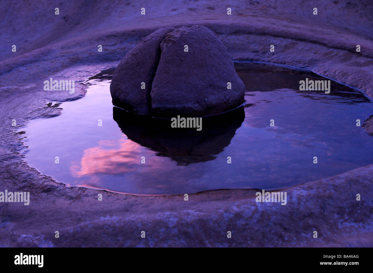 Small pond with a round stone on rock Stock Photo - Alamy