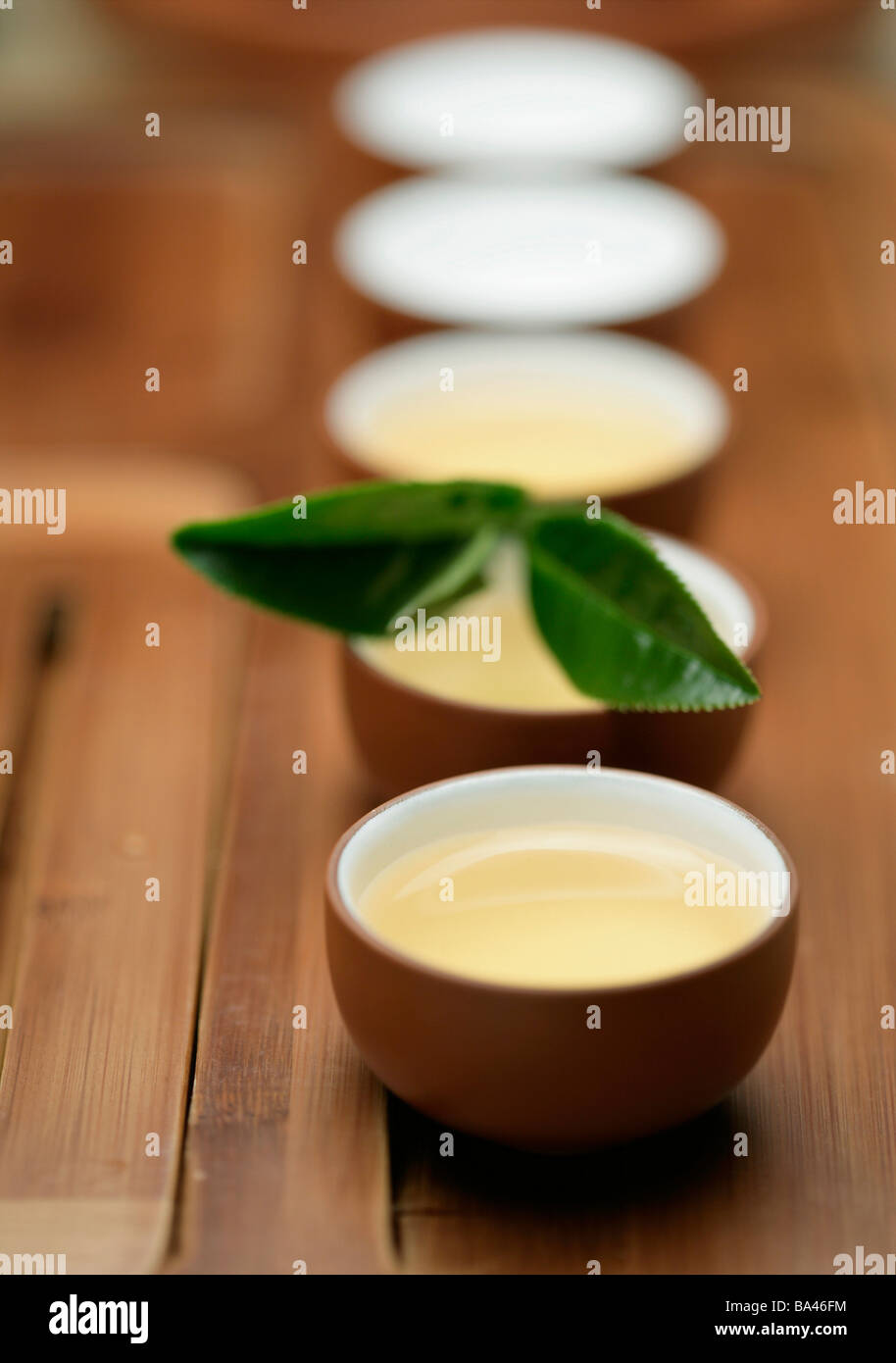 Tea cups in a row fresh tea leaves above Stock Photo - Alamy
