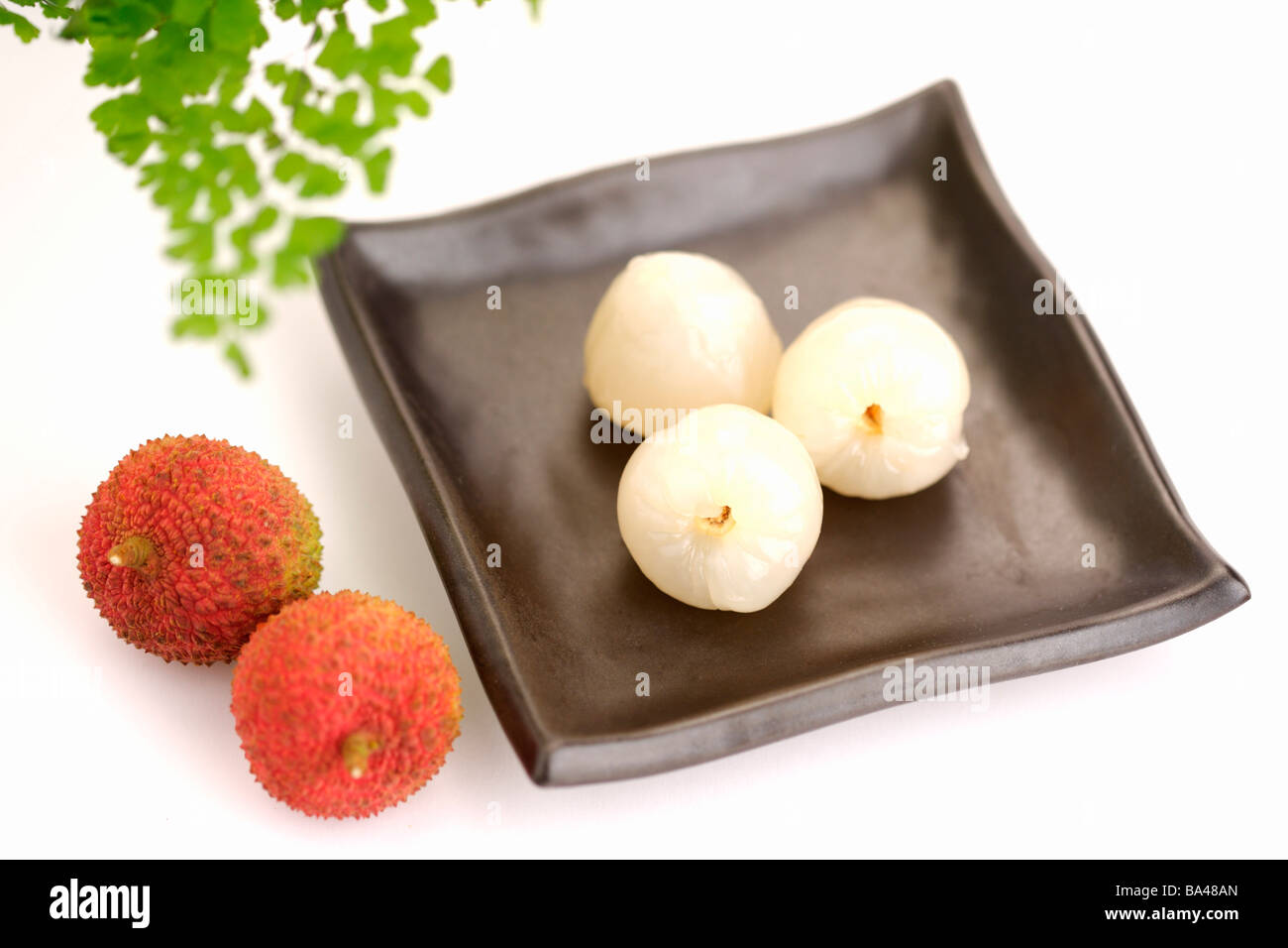 Lychees on and beside ceramic plate Stock Photo - Alamy