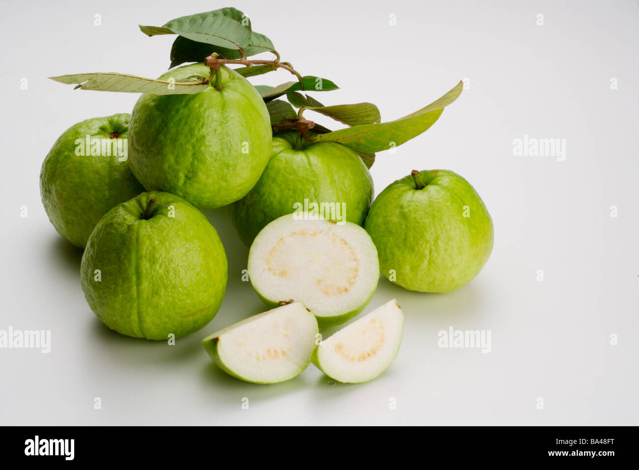 Four whole guavas and one cut open Stock Photo - Alamy