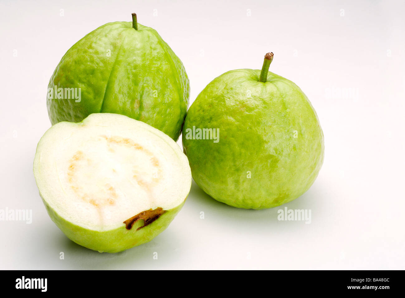 Two whole guavas and one cut open Stock Photo - Alamy