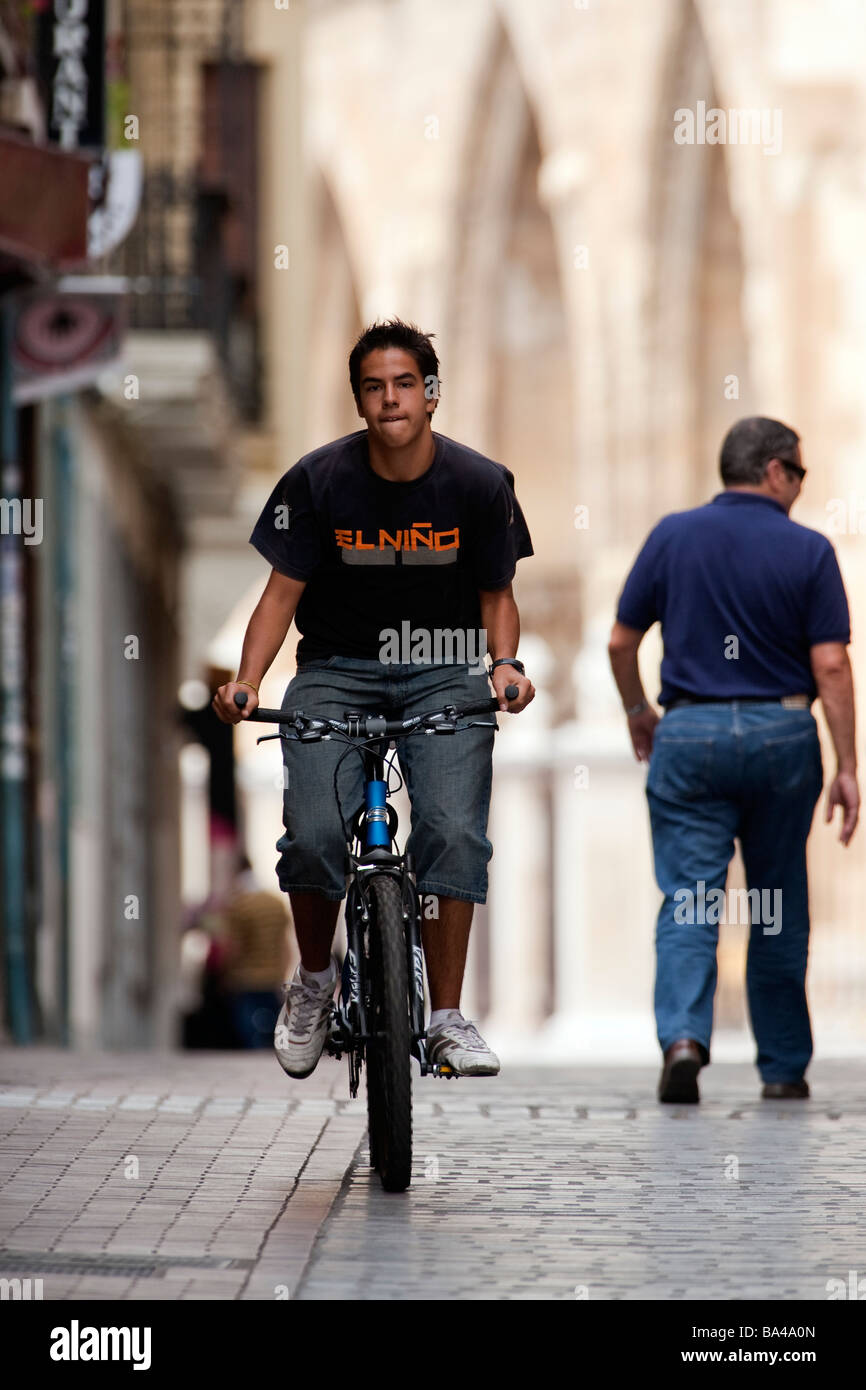 Boy riding a bike with the Cathedral on the background town of Leon ...