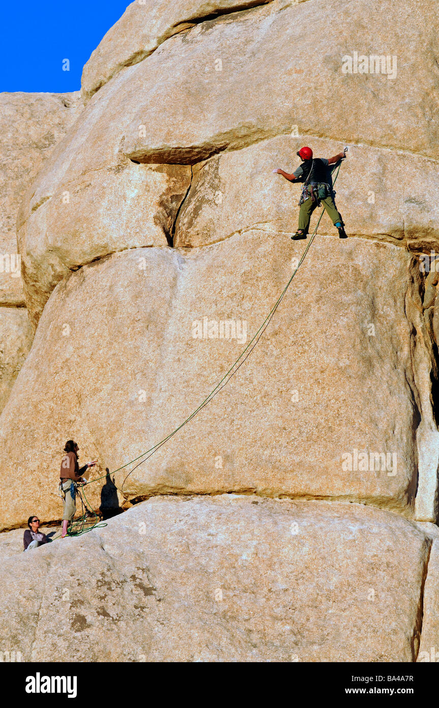 rock climber climbers getting ready to climb a rock wall face pinnacle ...