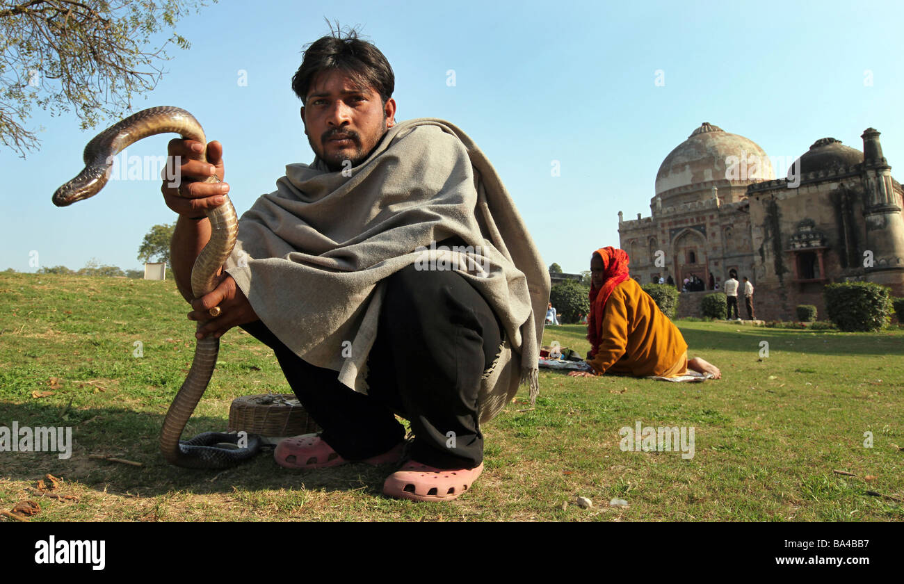 A snake charmer in New Delhi's tranquil Lodhi gardens squats in front ...