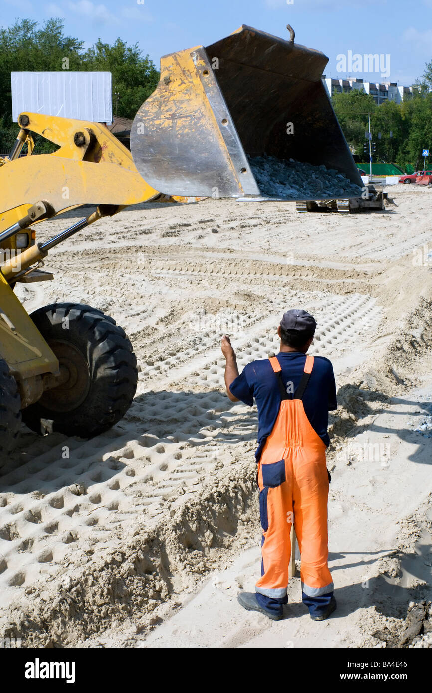 Worker and road loader Stock Photo - Alamy