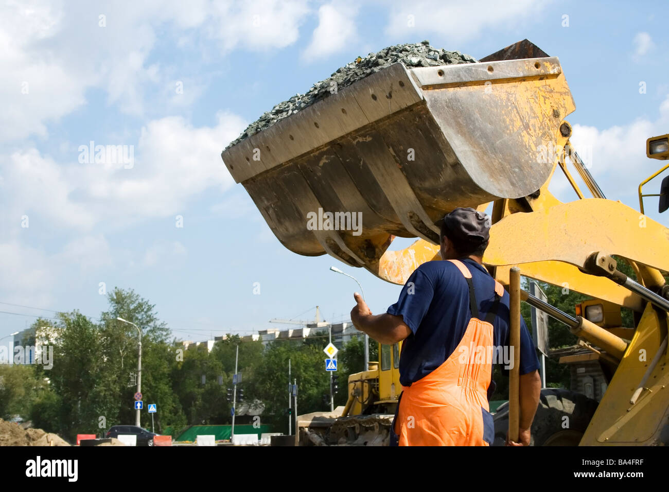 Worker and road loader Stock Photo - Alamy