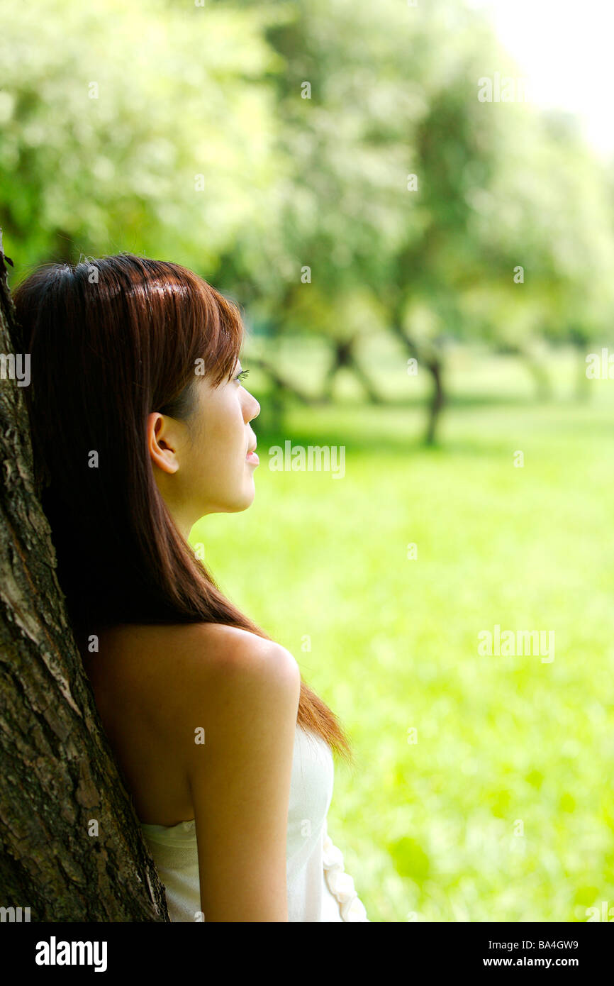 Young woman leaning on trunk rear view Stock Photo - Alamy