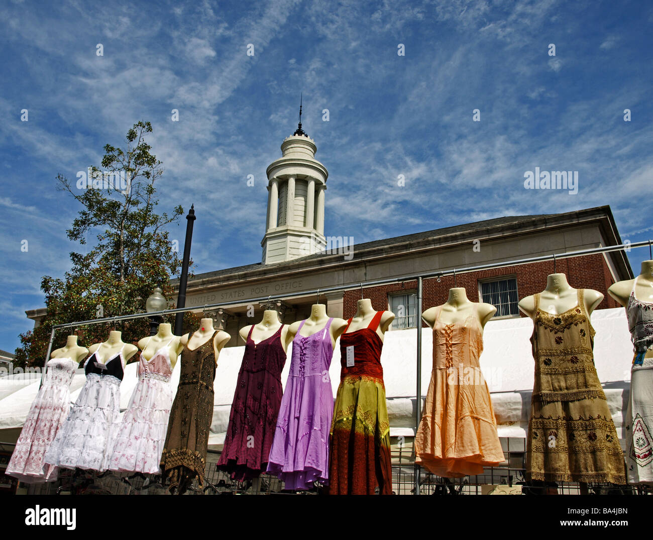 dresses for sale on armless mannequins hanging on rack with blue sky ...