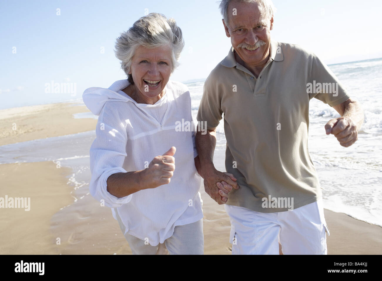 Beach senior-pair hands holds runs cheerfully omitted detail series ...