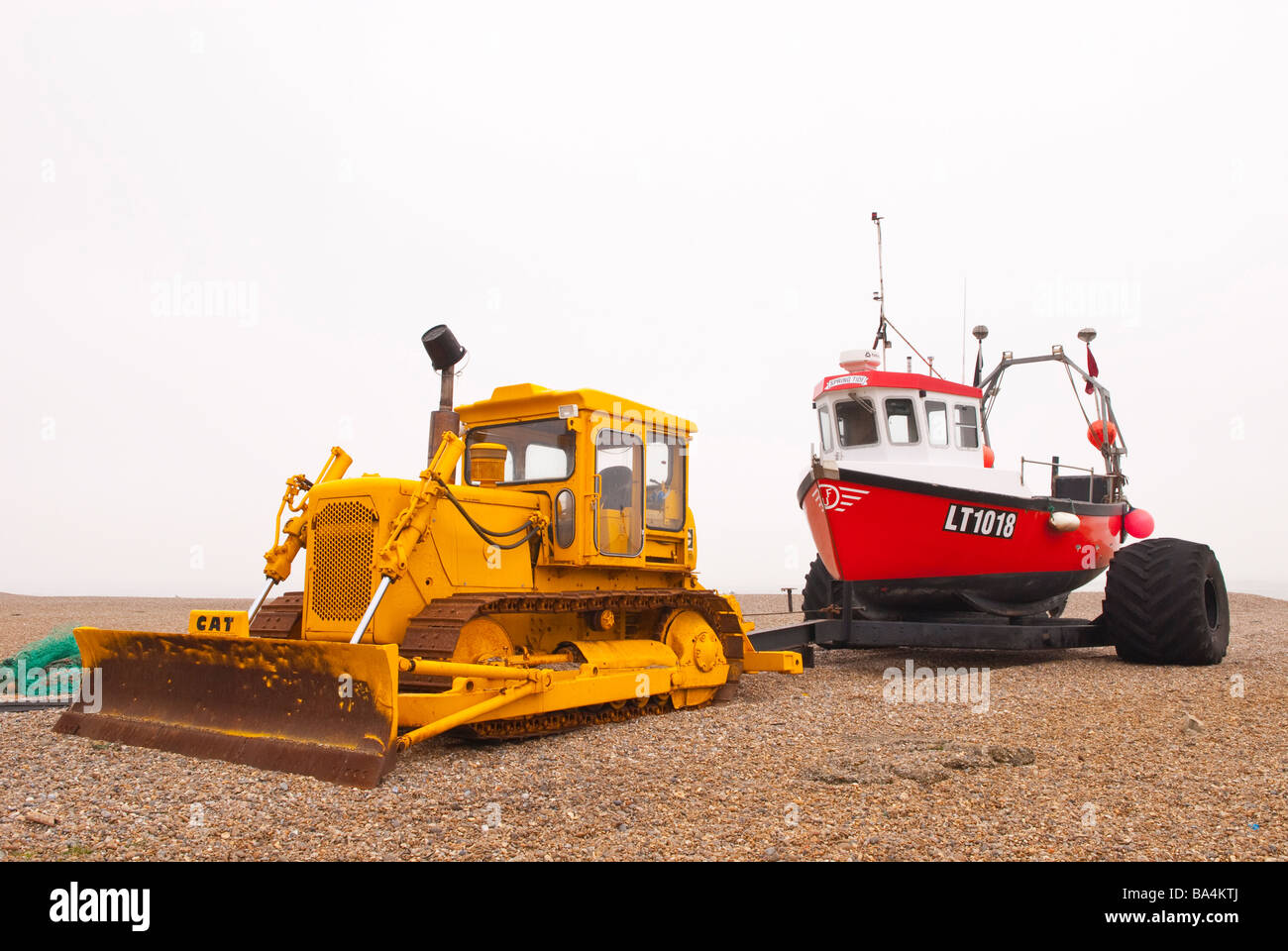 A cat bulldozer caterpillar tracked tractor pulling a fishing boat up ...