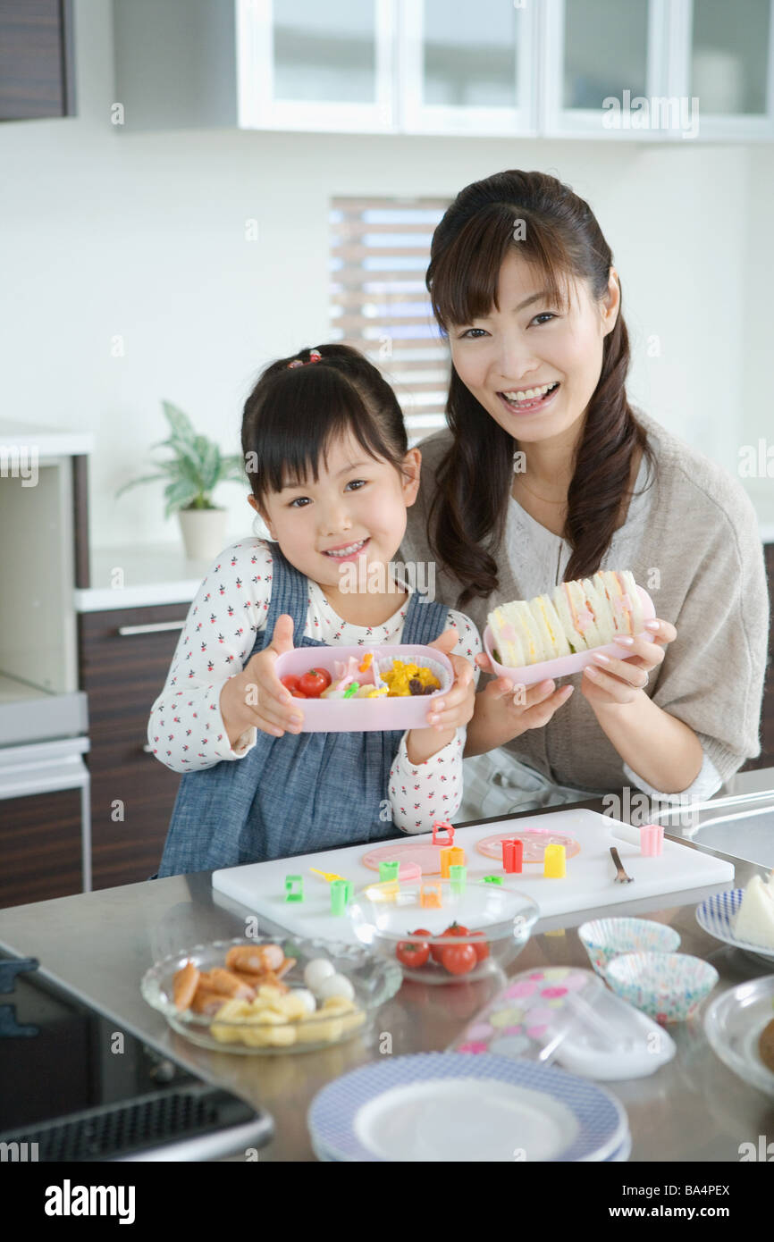 Mother with daughter packing lunch box Stock Photo - Alamy