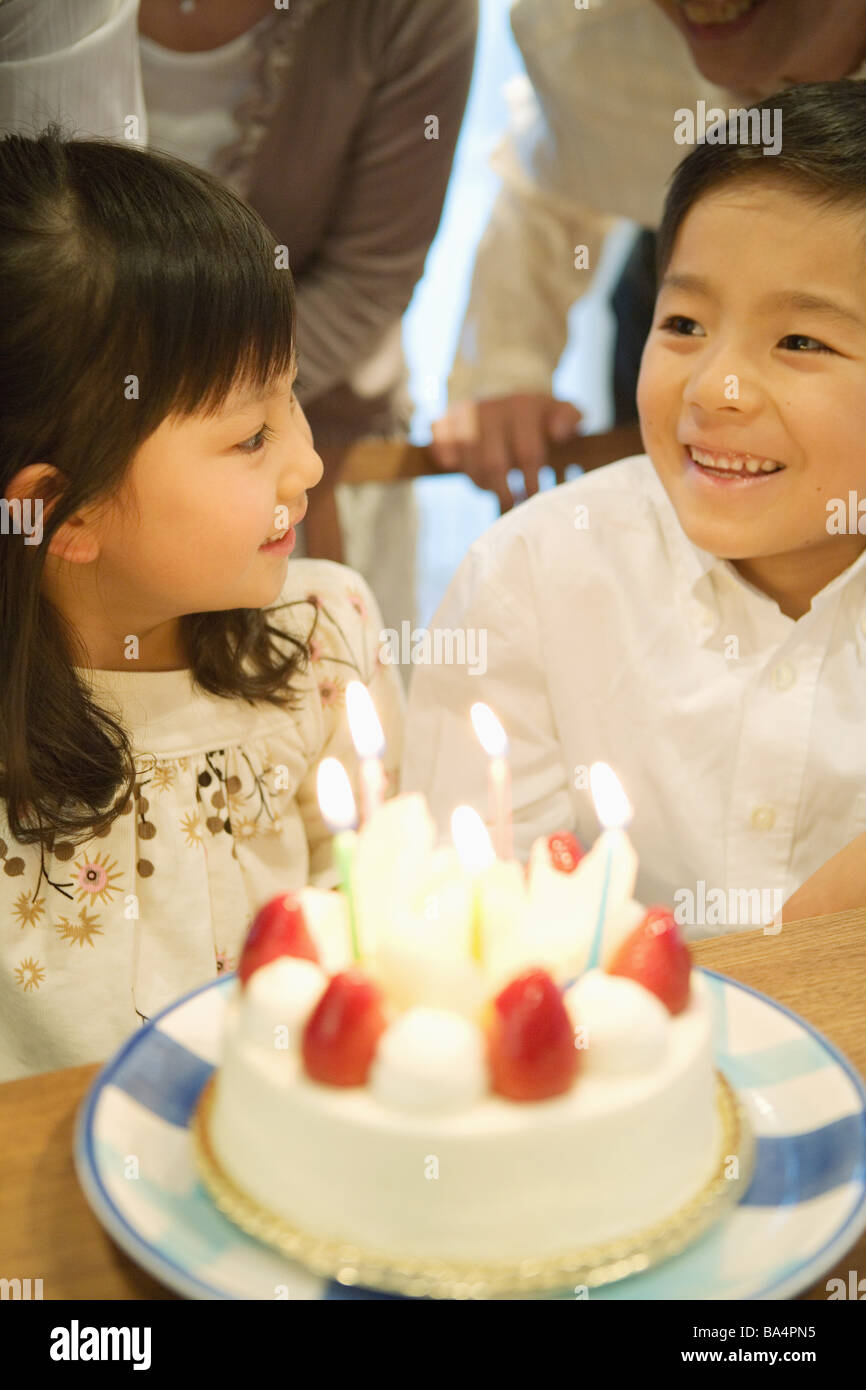 Children standing with birthday cake Stock Photo - Alamy