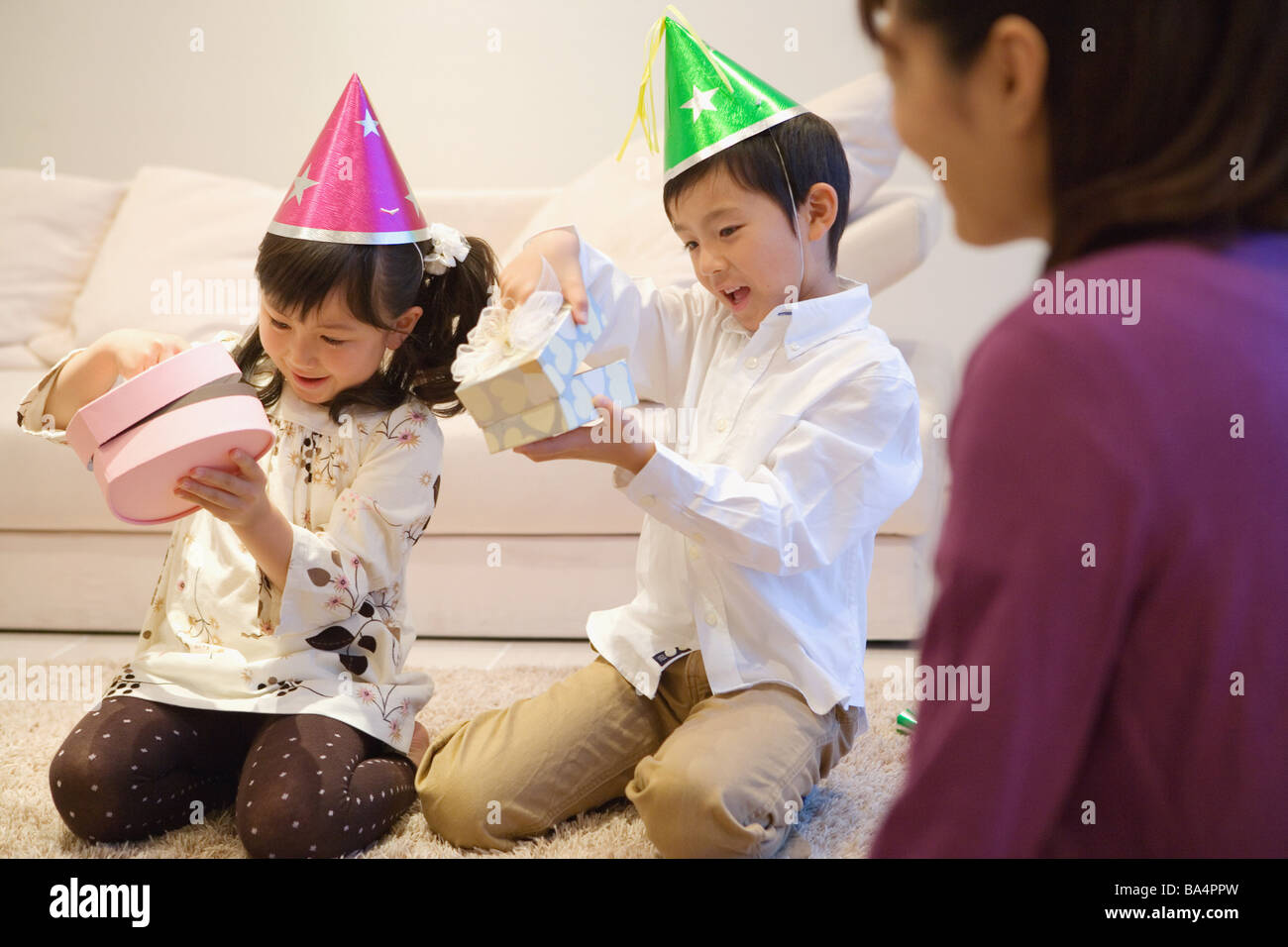 Child opening their present with mother Stock Photo - Alamy