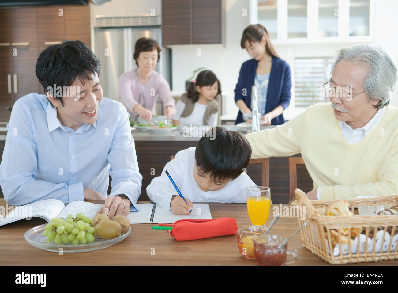 Boy doing homework with his family Stock Photo - Alamy