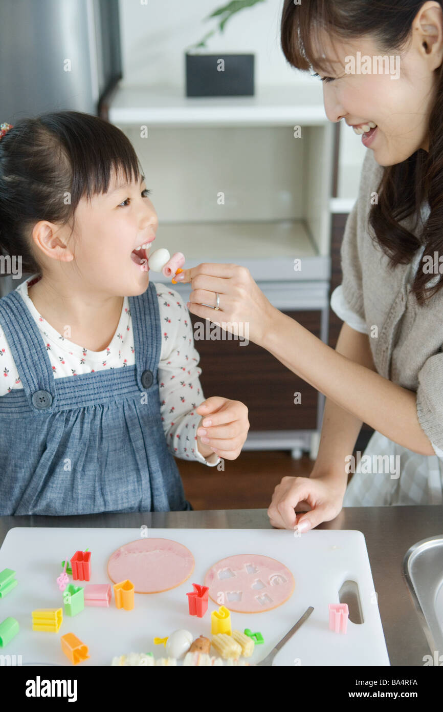 Mother feeding snacks to his daughter Stock Photo - Alamy
